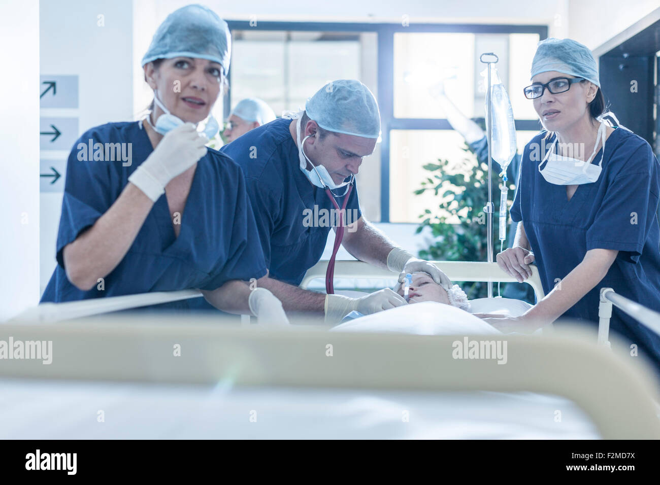 Surgeons at hospital bed with patient Stock Photo - Alamy