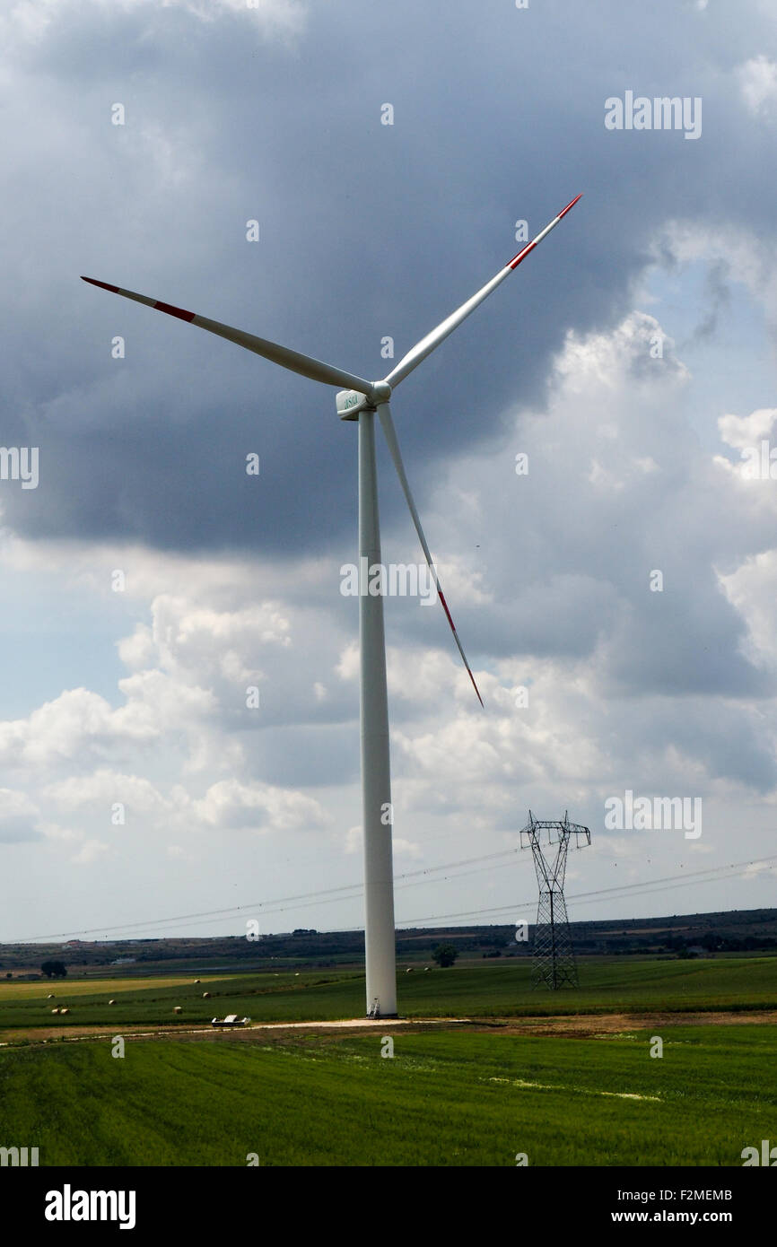 Wind turbine and high power transmission wires in green farmland Stock ...