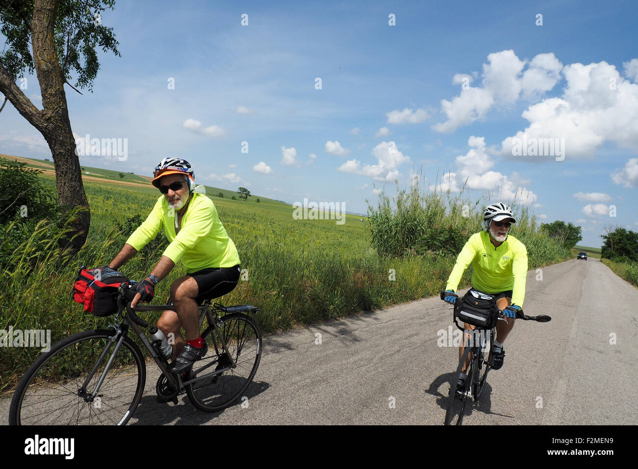 Two touring cyclists cycling on a country road Stock Photo - Alamy