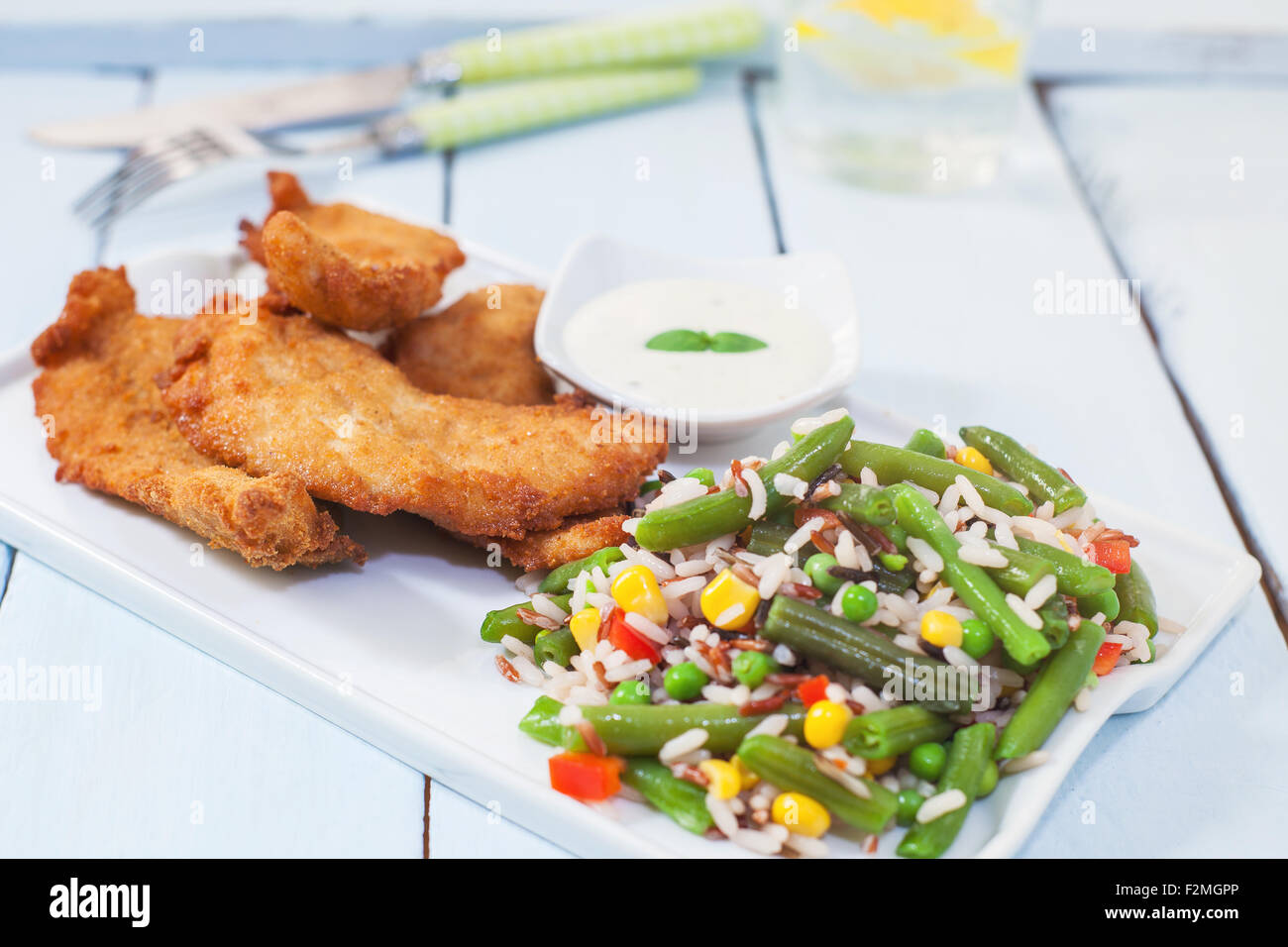 rice and vegetables salad with chicken fingers selective focus on rice ...