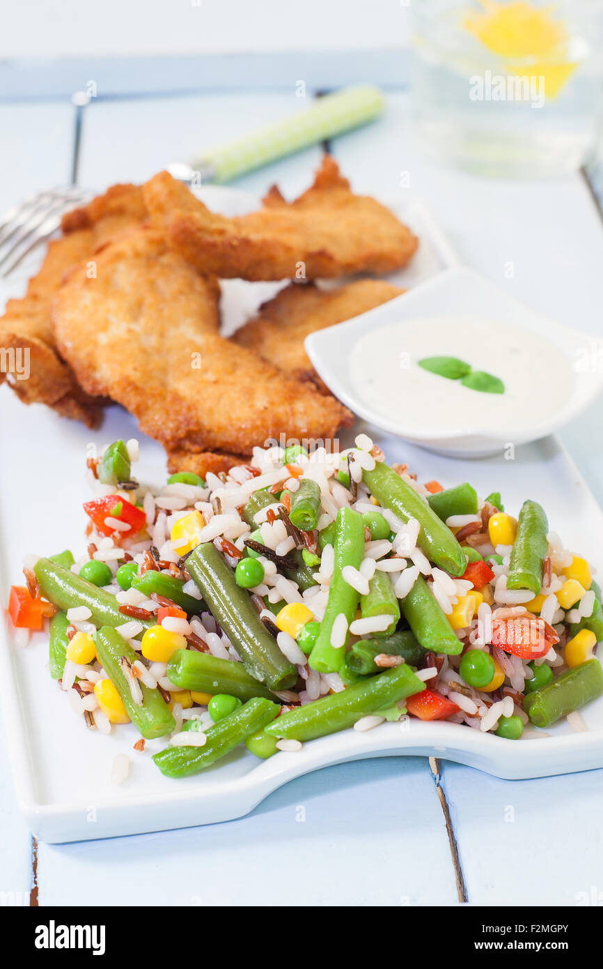 rice and vegetables salad with chicken fingers selective focus on rice ...