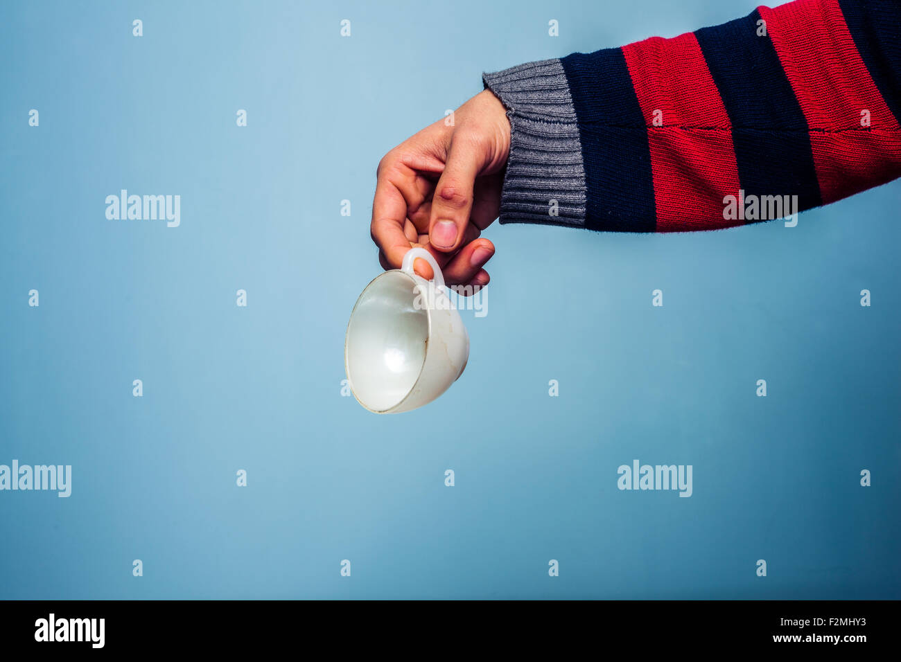 Male hand holding empty cup Stock Photo - Alamy