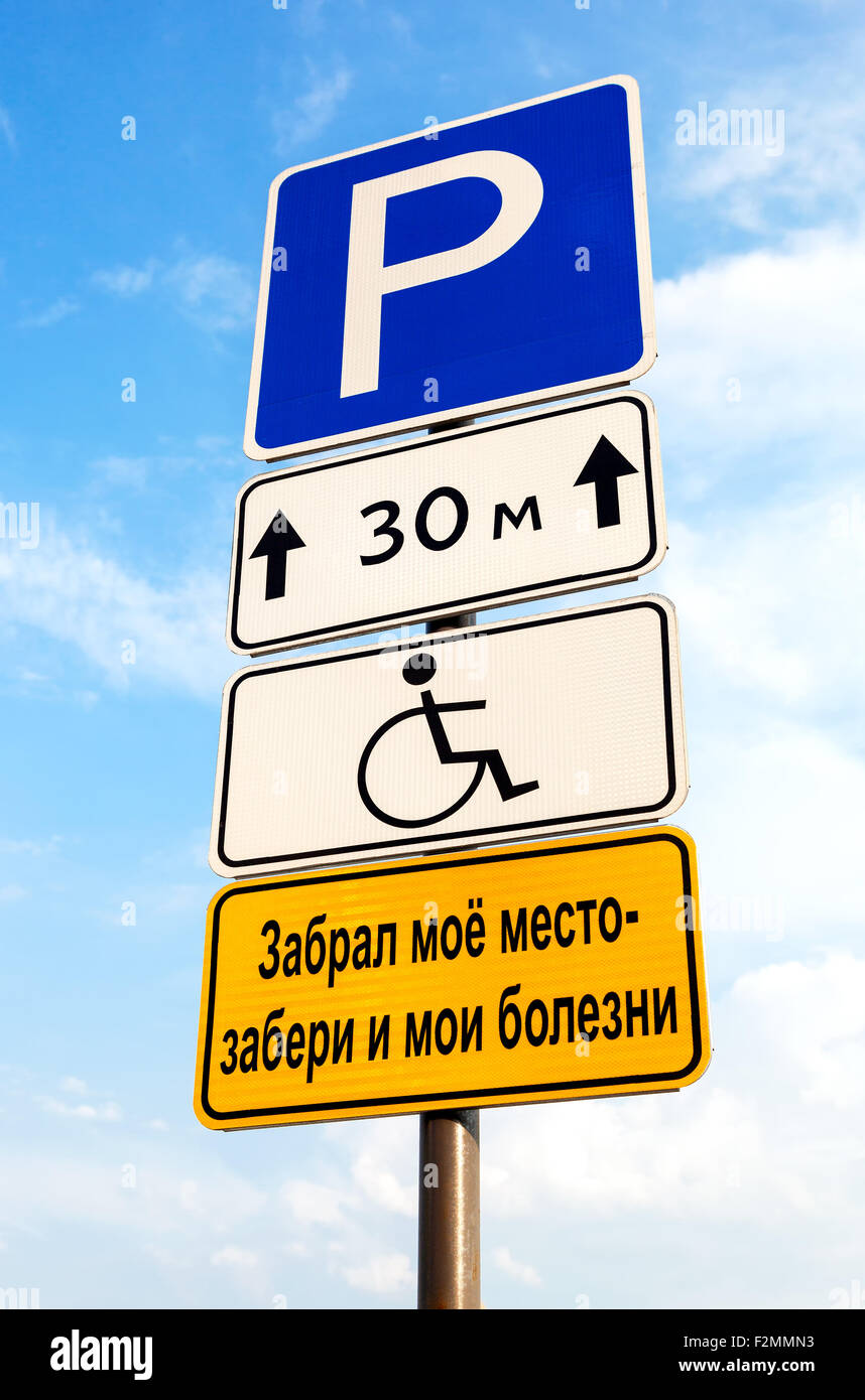 Handicapped parking sign against blue sky. Text in Russian: Took my ...