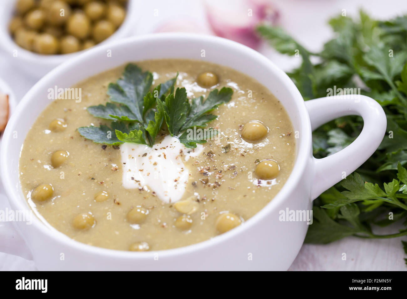 A delicious pea cream with aromatic spices on a wooden table. Studo ...