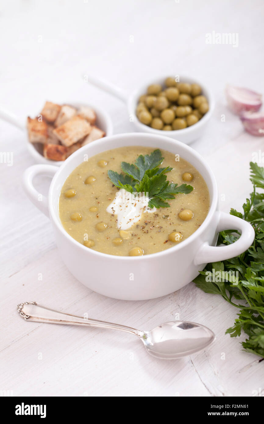 A delicious pea cream with aromatic spices on a wooden table. Studo ...