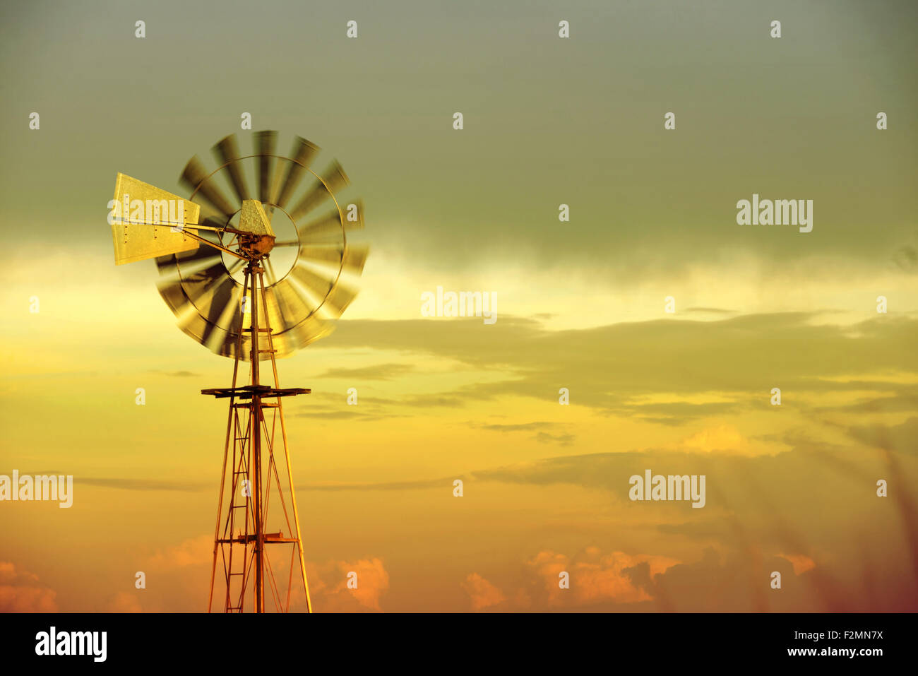 Countryside skyline with wind mill over sunset clouds in the background ...
