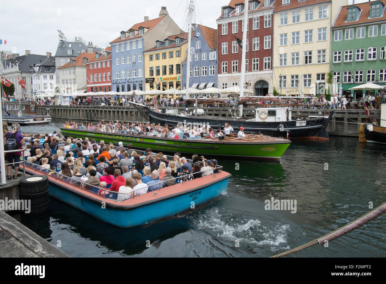 Tourists taking a canal trip at Nyhavn New Harbour Copenhagen Denmark ...