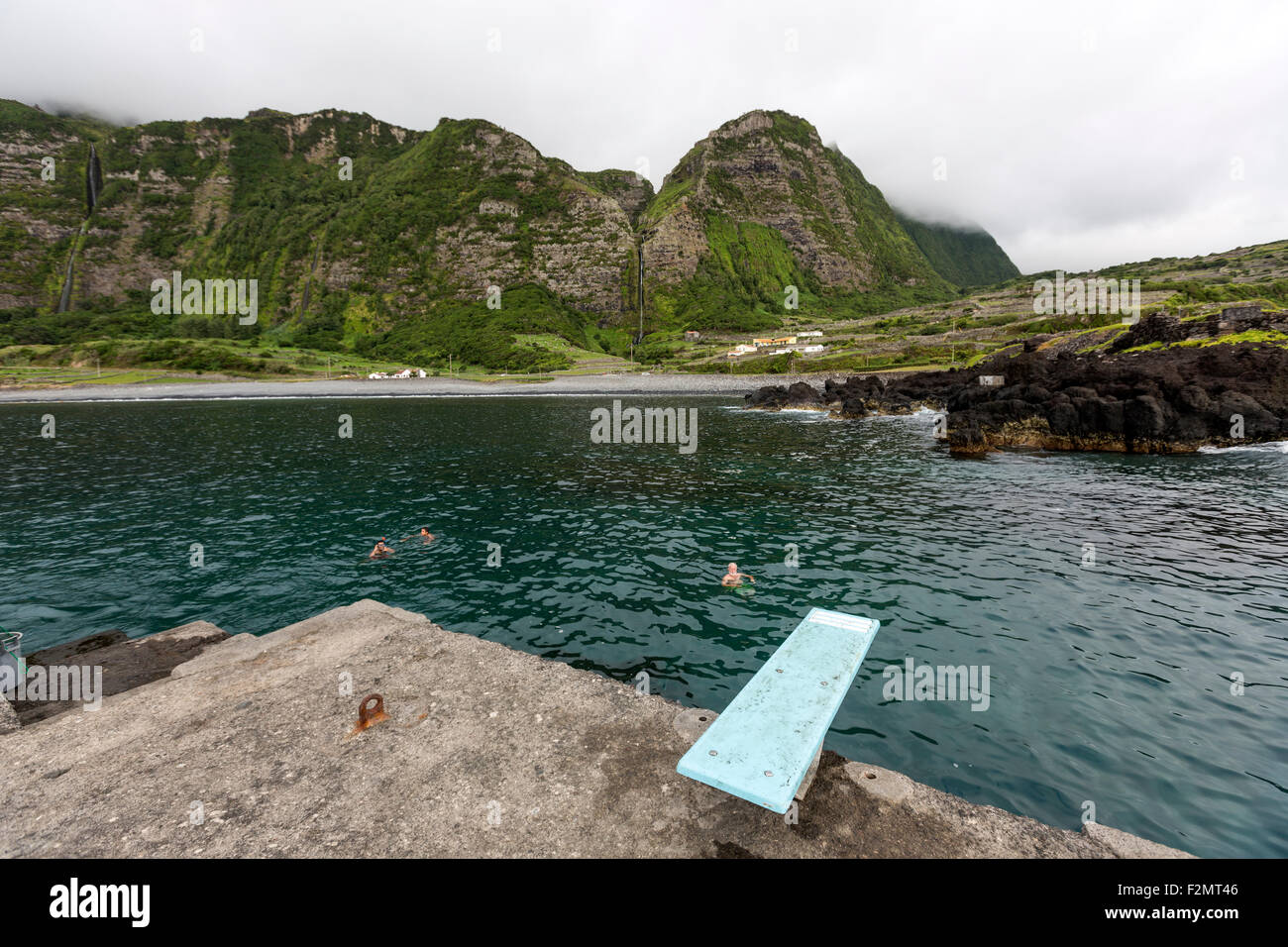 People swimming in Ponta Delgada surrounding by waterfalls, Flores ...