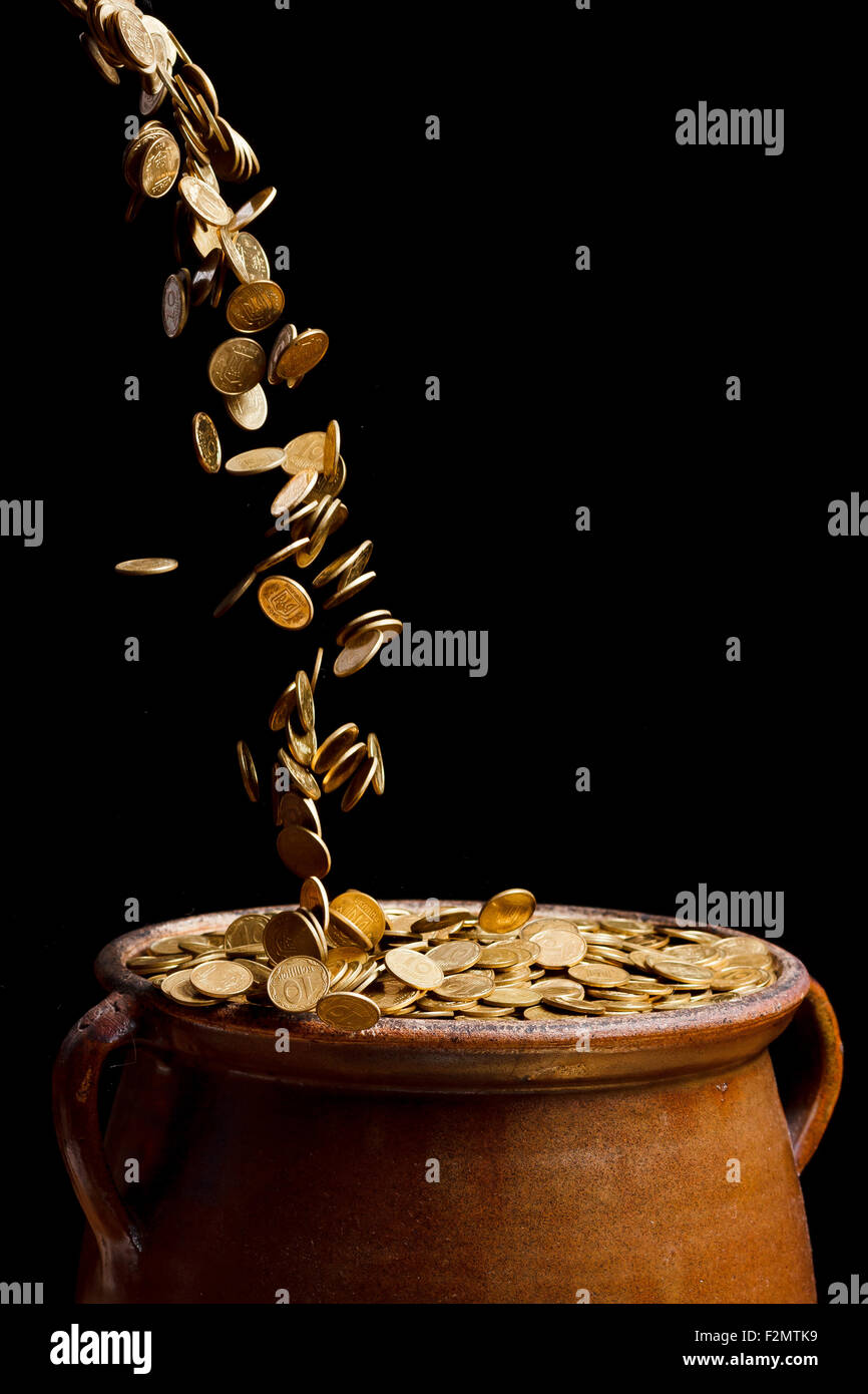 gold coins falling in the vintage pot Stock Photo - Alamy