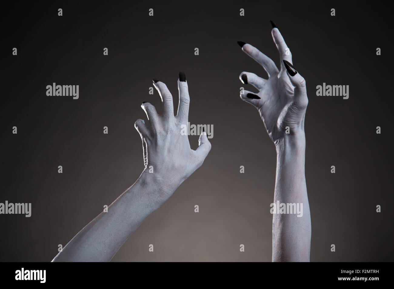 Spooky Halloween white hands with black nails stretching up, body art ...