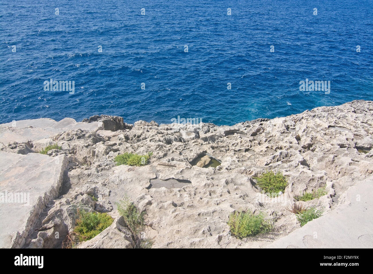 Natural limestone along the coast and blue Mediterranean water in Malta ...