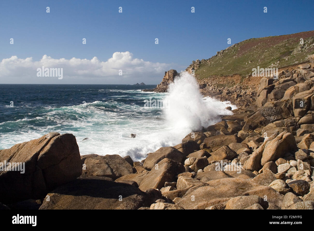 Wave crashes into rock Stock Photo - Alamy