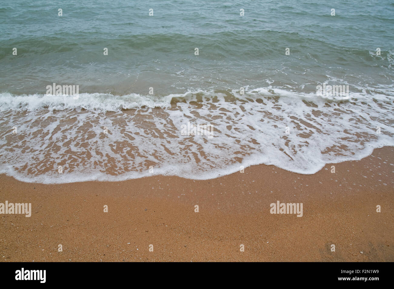 Sea wave over sand Stock Photo - Alamy