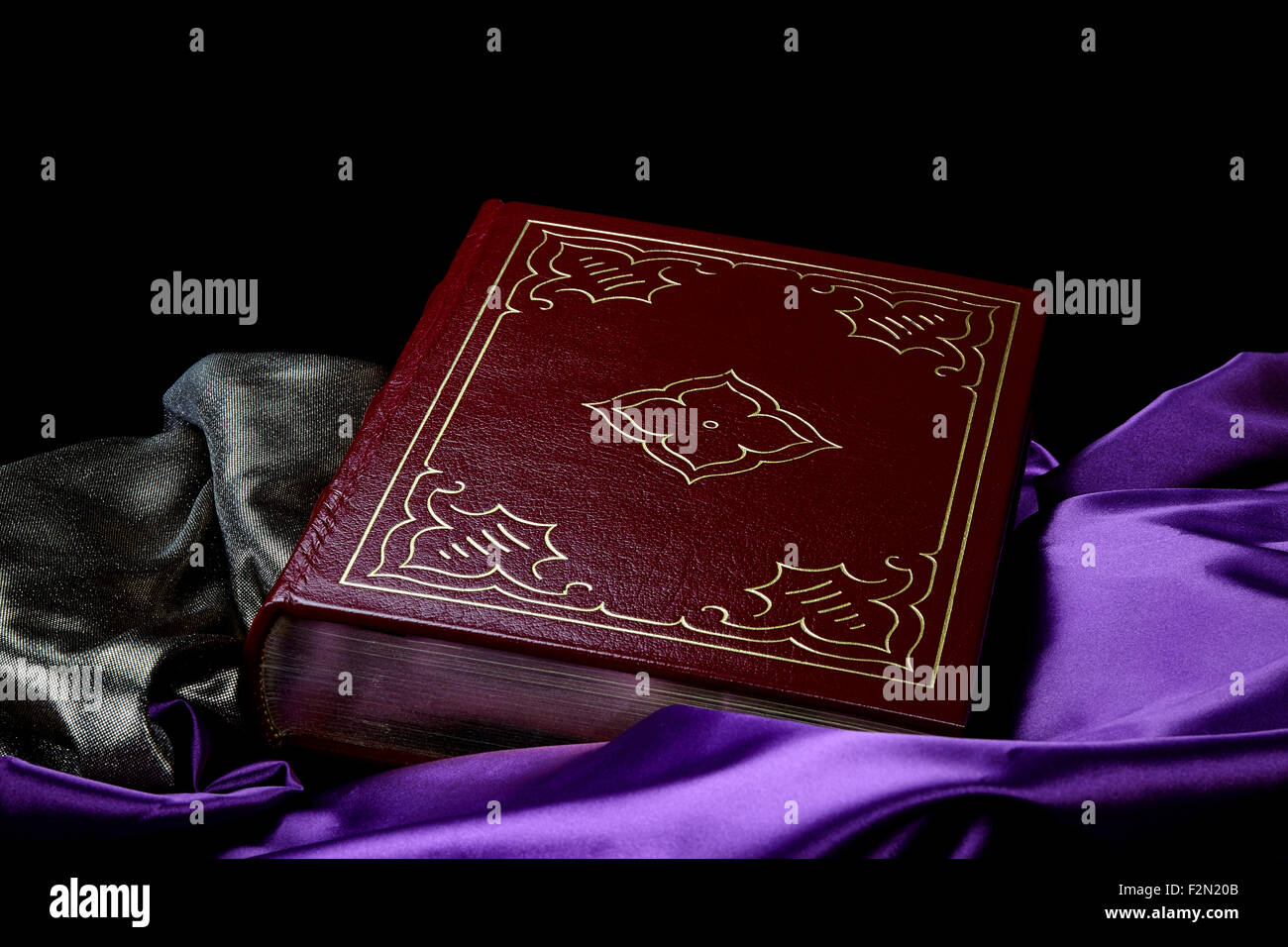 Vintage Book on Purple Satin on Black Stock Photo - Alamy