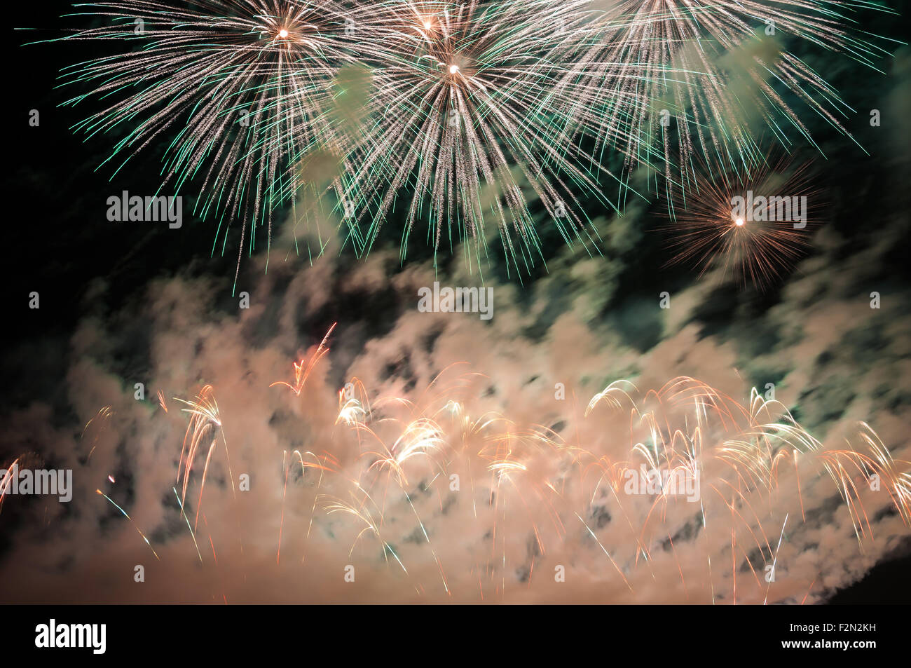 Beautiful fireworks on the night cloudy sky Stock Photo - Alamy