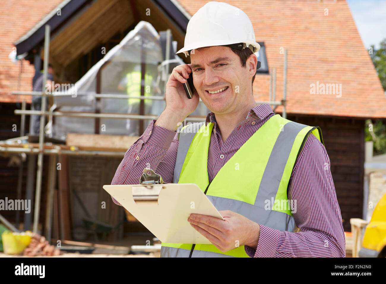Architect On Building Site Using Mobile Phone Stock Photo - Alamy