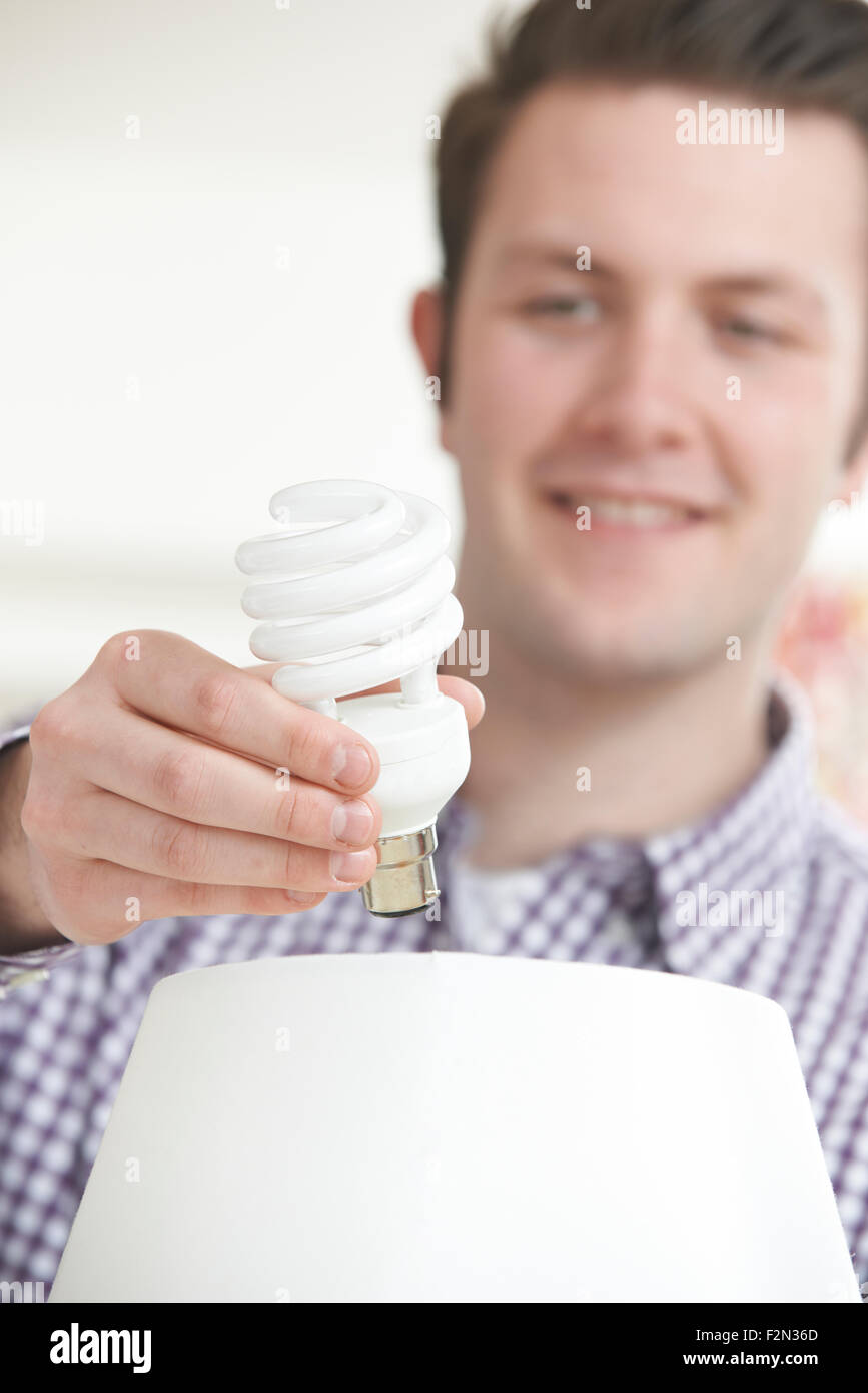Man Putting Low Energy Lightbulb Into Lamp At Home Stock Photo - Alamy