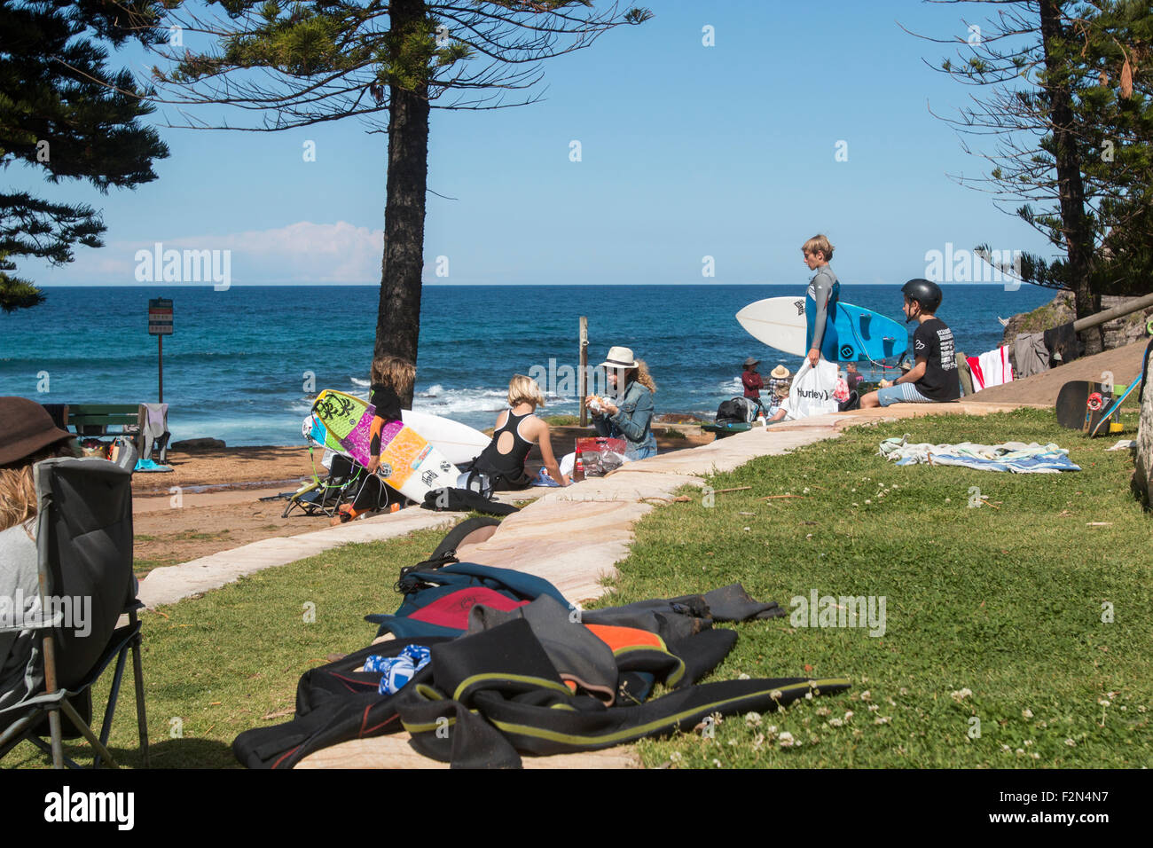 Avalon beach in Sydney with surfers and wetsuits laying around ...