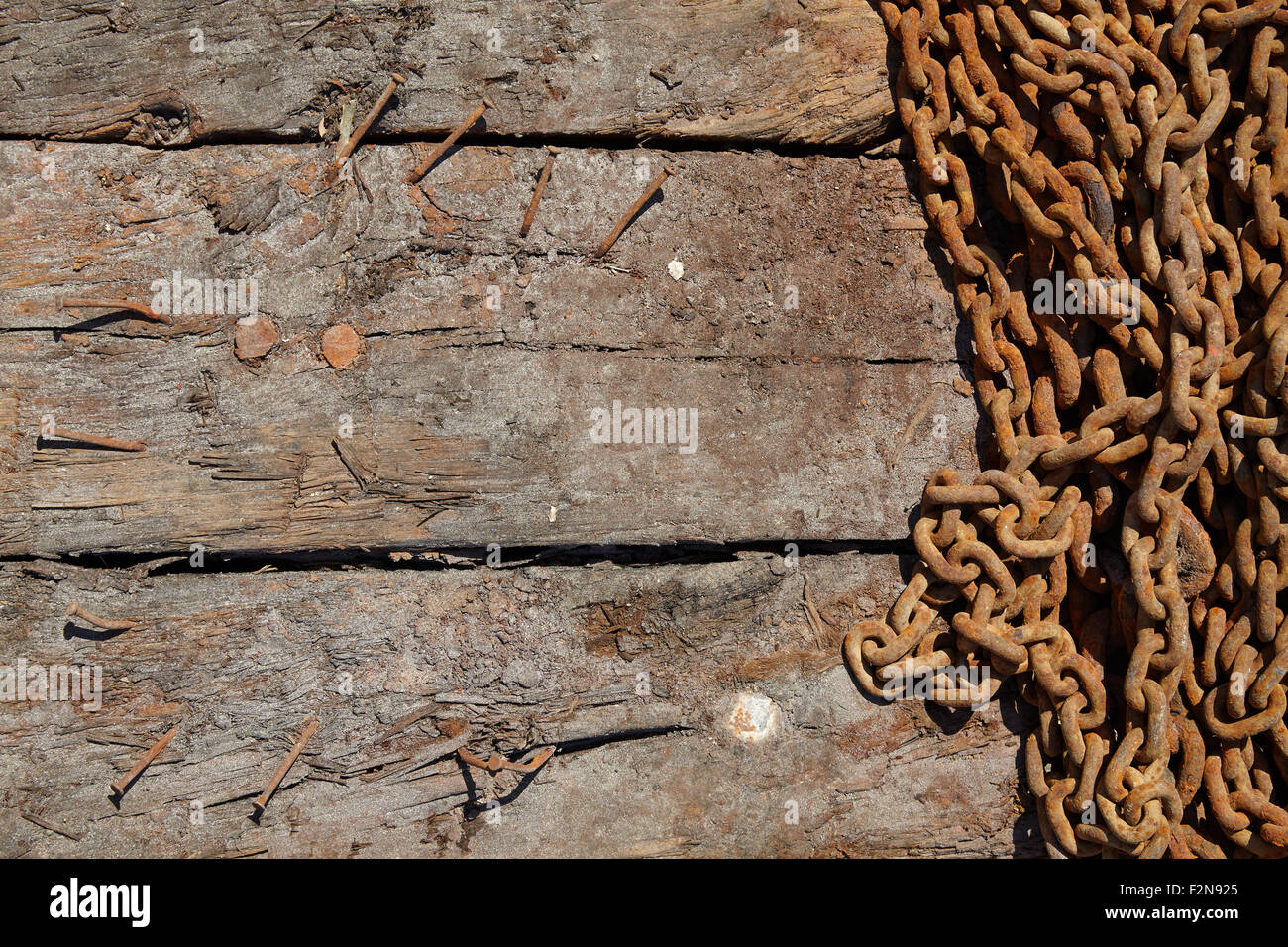 rusty iron chain on a wooden texture background Stock Photo - Alamy