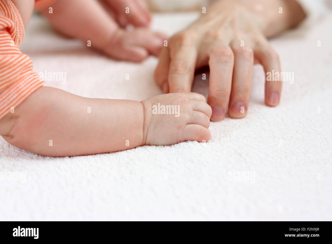 Baby holding finger Stock Photo - Alamy