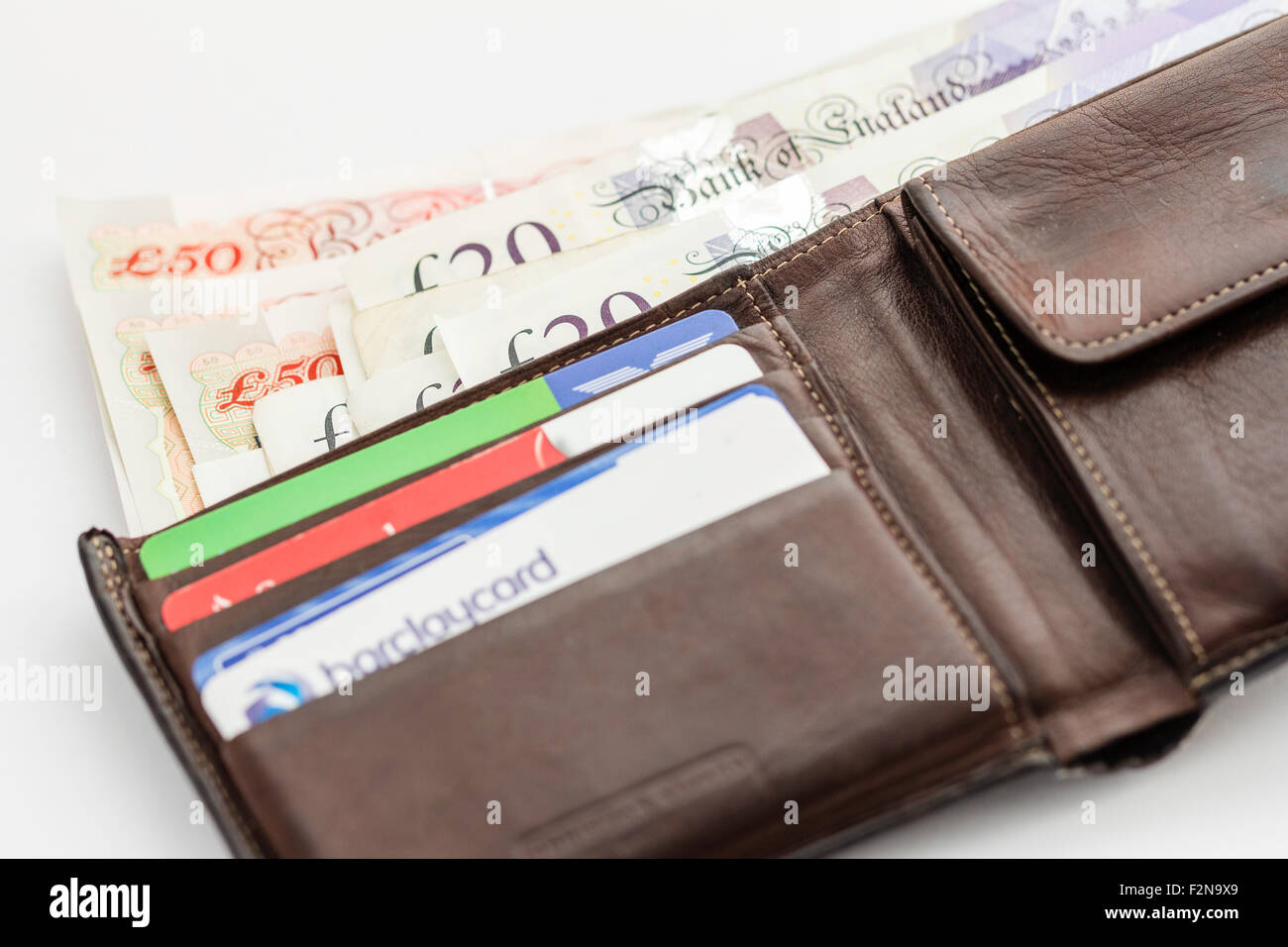 Close up of open brown leather wallet showing plastic credit cards and ...