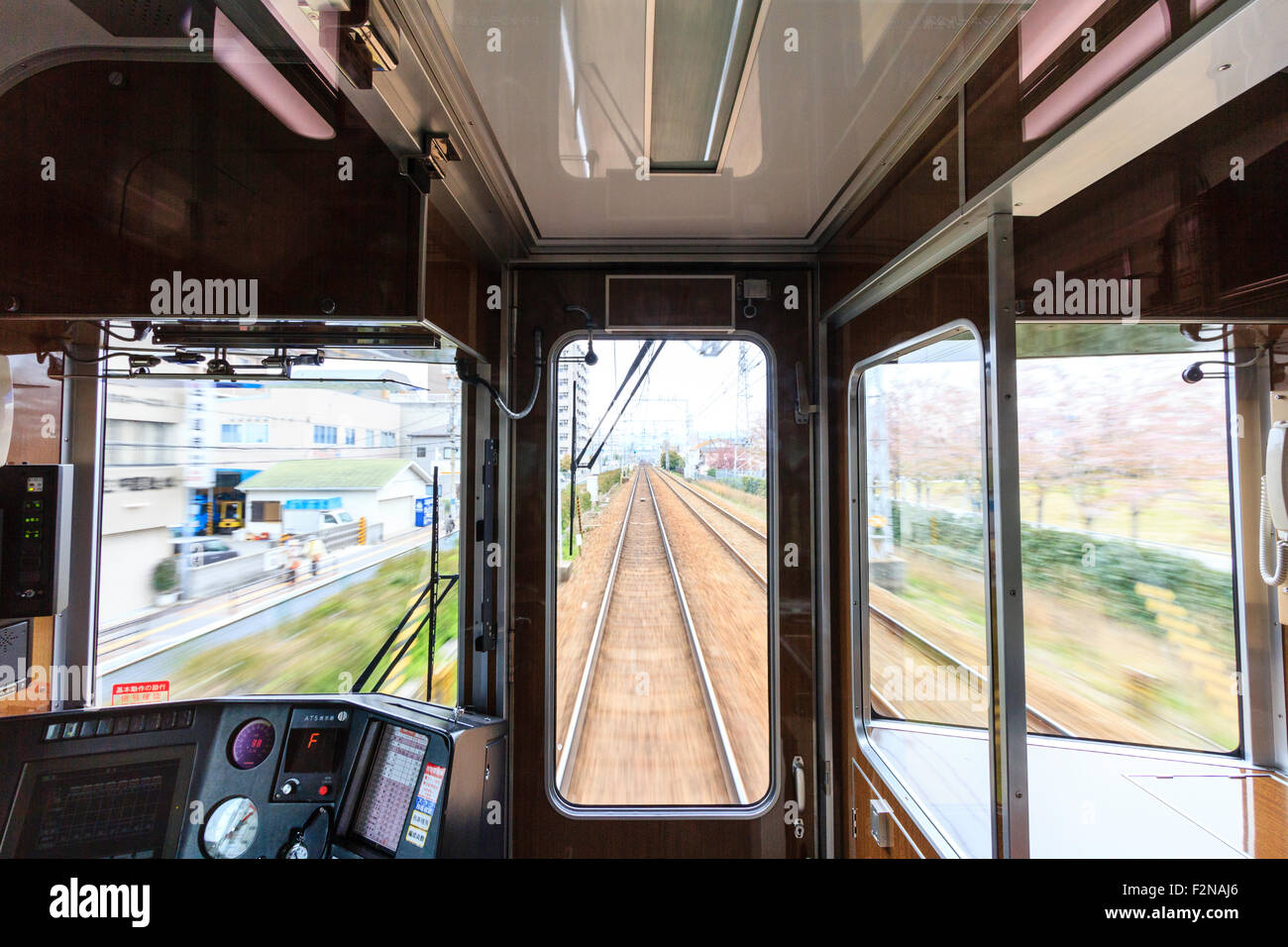 Japan, Osaka. Hankyu railway. View through the drivers cab windows at front of train as it ...