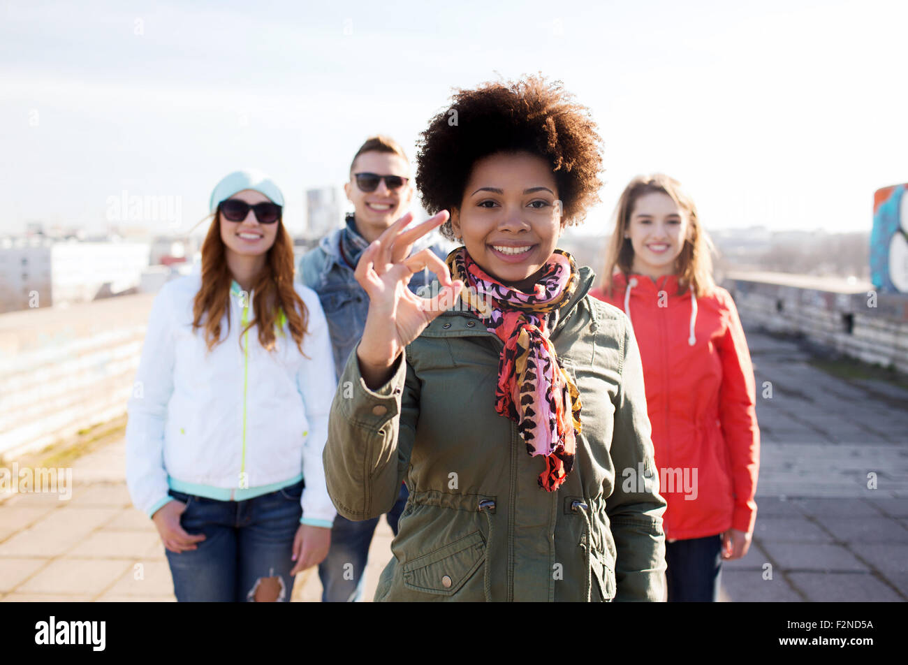 happy teenage friends showing ok sign on street Stock Photo - Alamy
