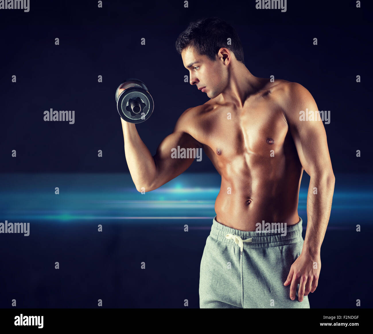 young man with dumbbell flexing biceps Stock Photo - Alamy