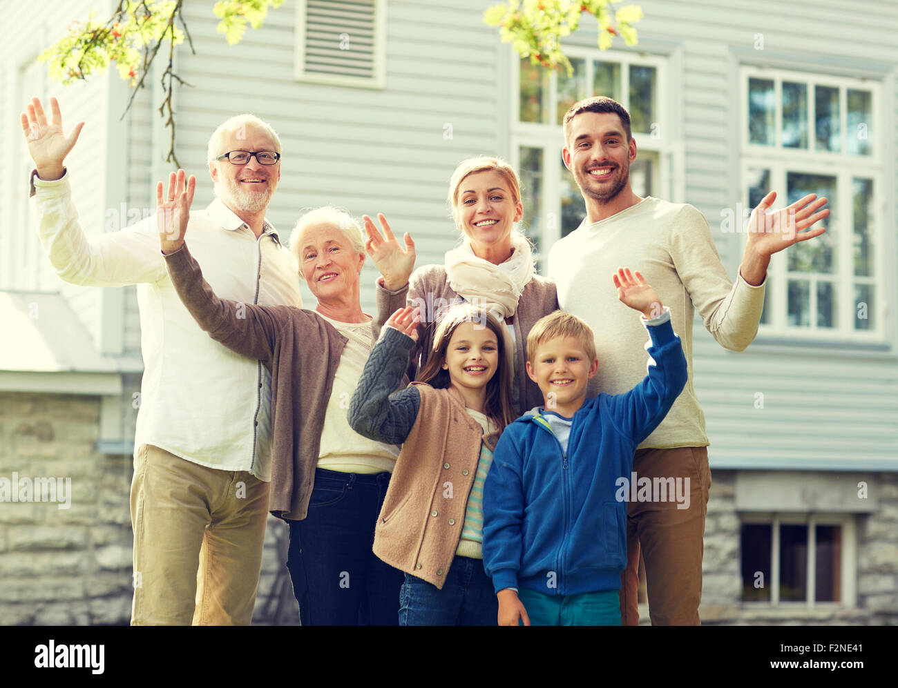 happy family waving hands in front of house Stock Photo - Alamy