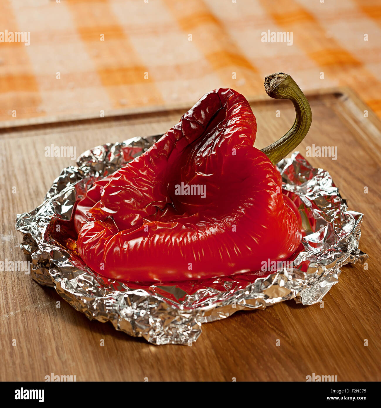 Fried red pepper vegetable in foil on wood table Stock Photo - Alamy