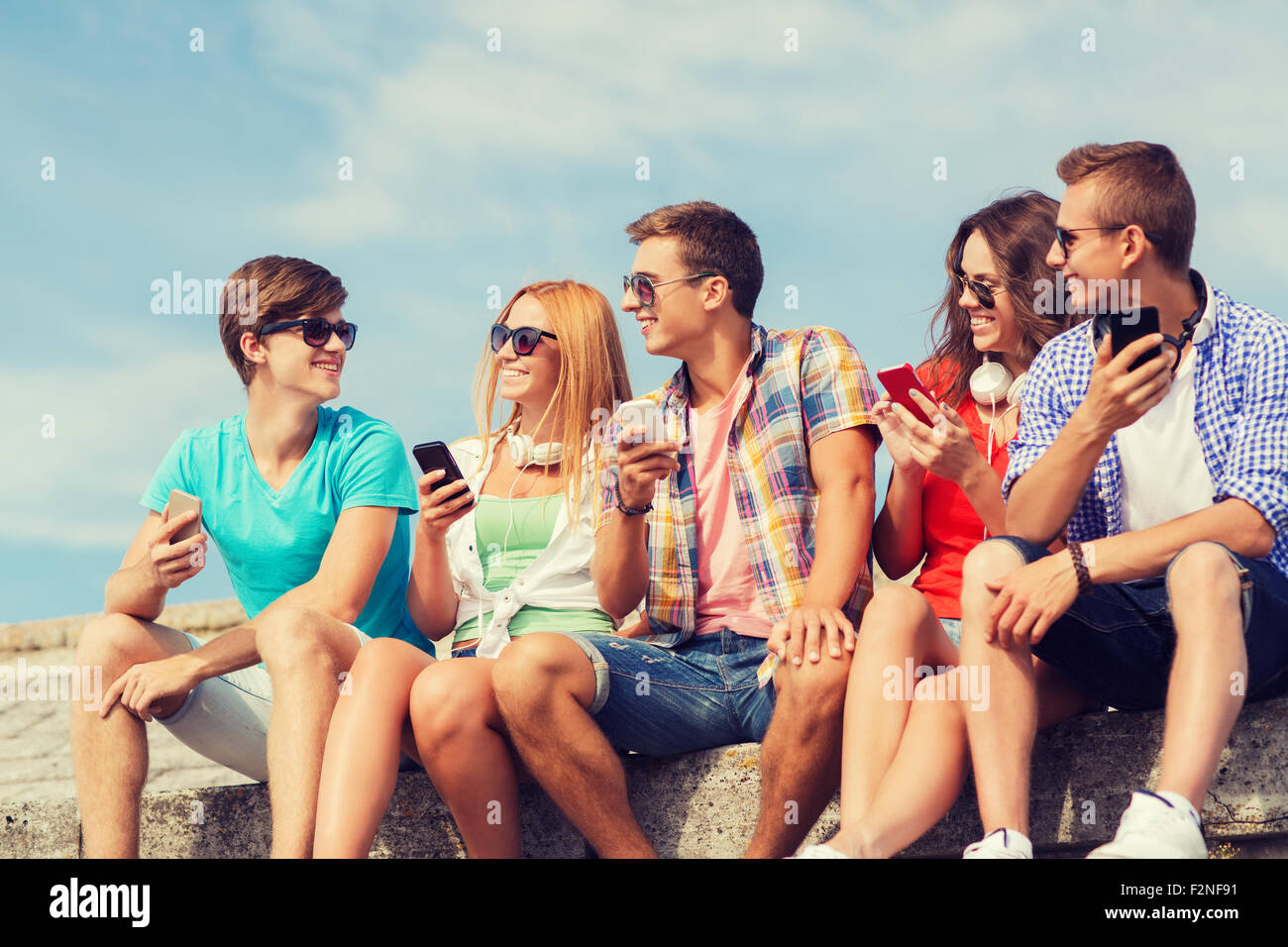 group of smiling friends with smartphones outdoors Stock Photo - Alamy