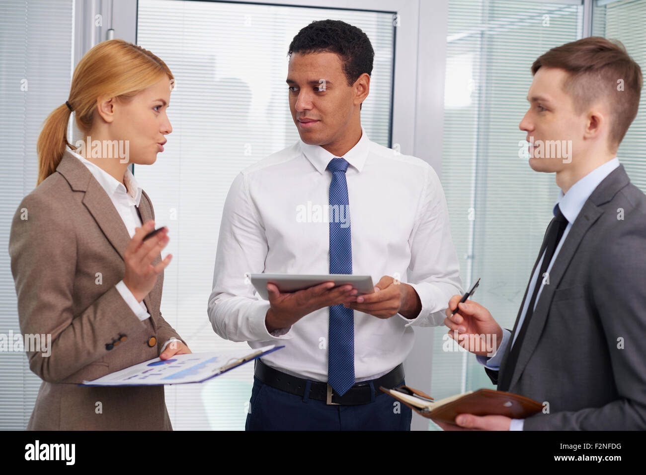 Serious colleagues discussing their plans and ideas in office Stock ...