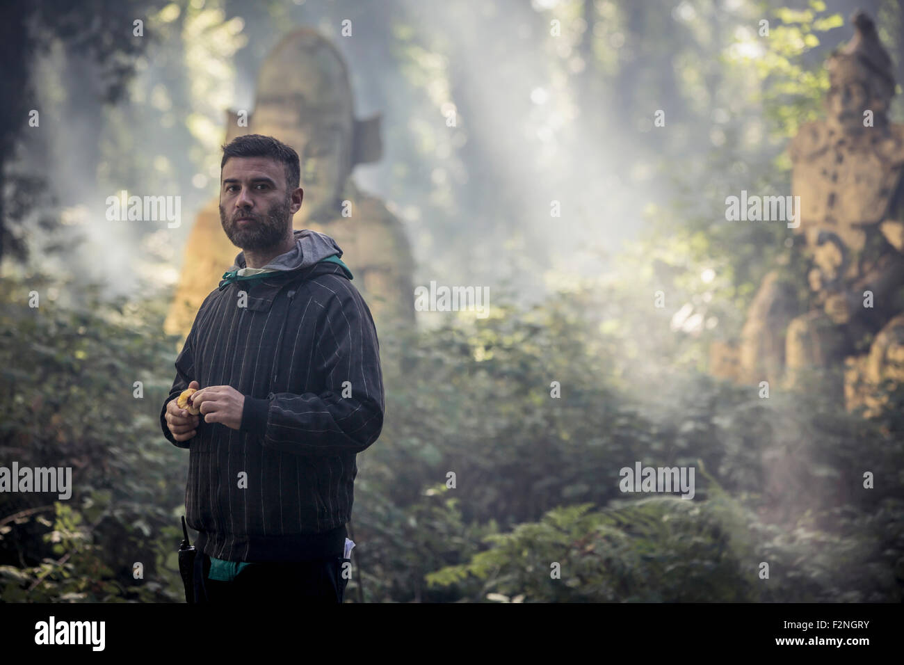 Caucasian man exploring ancient statues in forest Stock Photo - Alamy