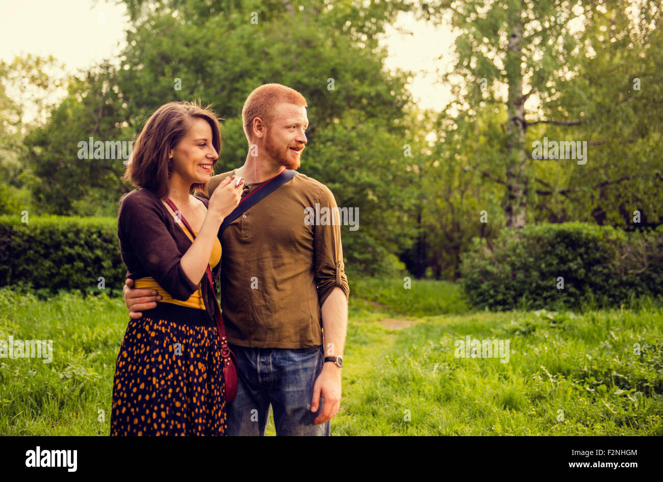 Caucasian couple hugging in field Stock Photo - Alamy