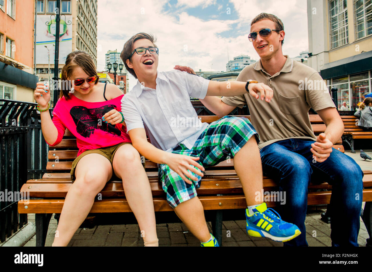 Caucasian friends playing on city bench Stock Photo - Alamy