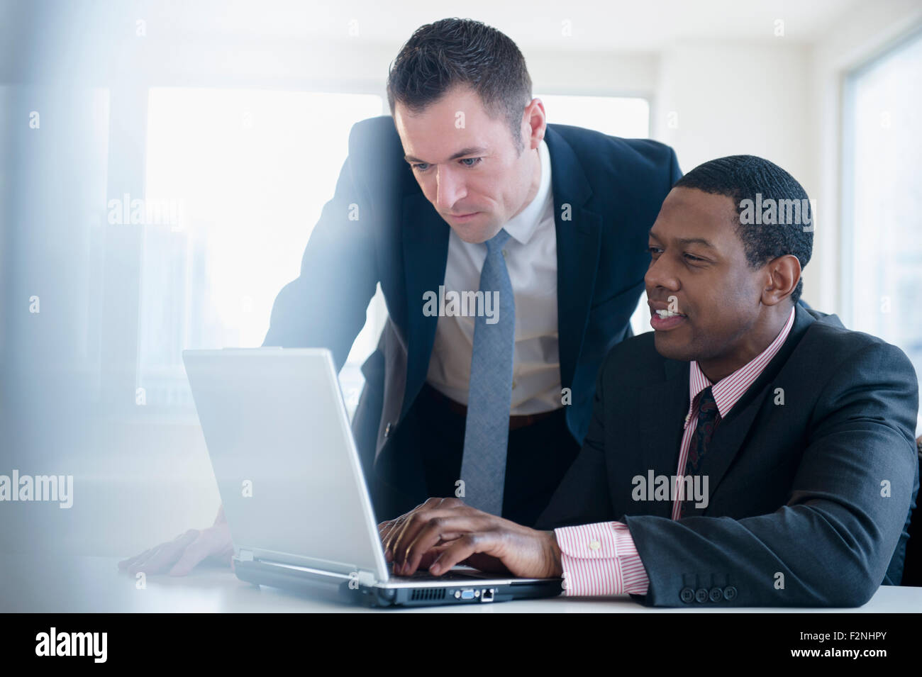 Businessmen using laptop in office Stock Photo - Alamy