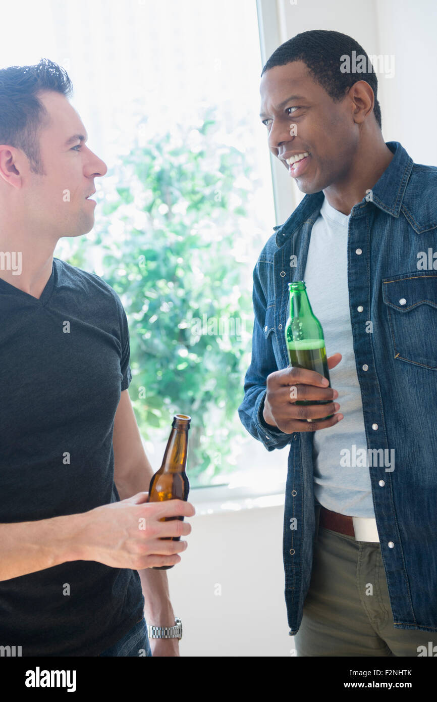 Men drinking beer near window Stock Photo - Alamy