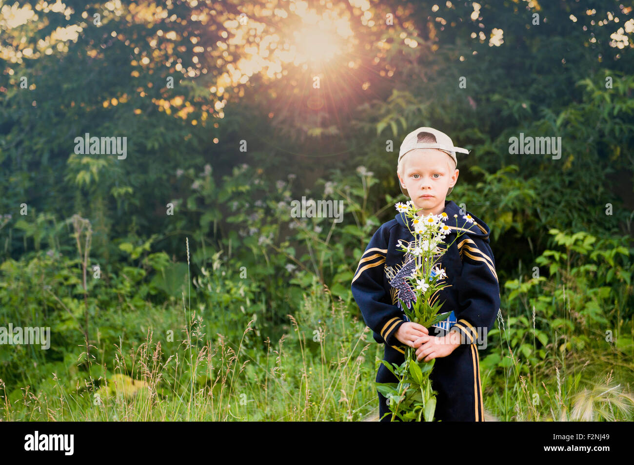 Caucasian boy picking flowers in rural field Stock Photo - Alamy