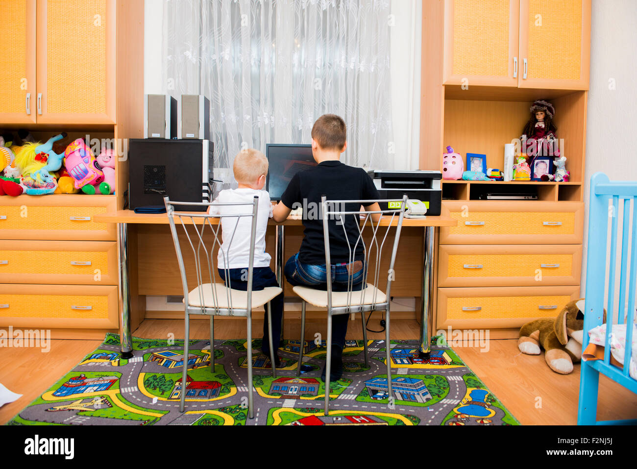 Caucasian brothers using computer in bedroom Stock Photo - Alamy