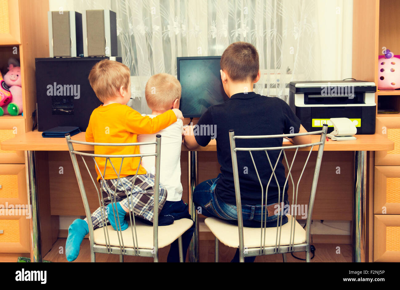 Caucasian brothers using computer in bedroom Stock Photo - Alamy