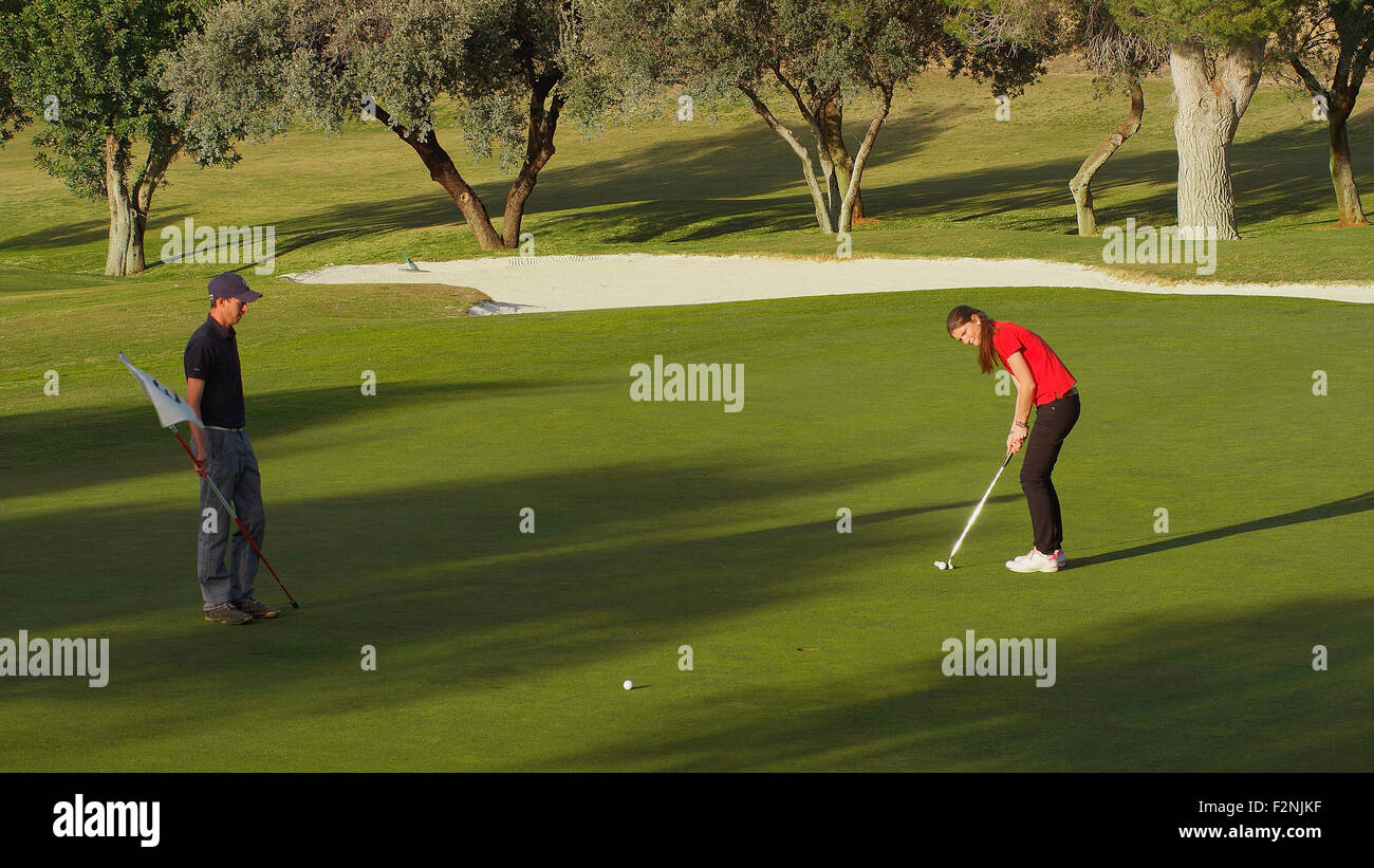 Caucasian couple putting on golf course Stock Photo - Alamy