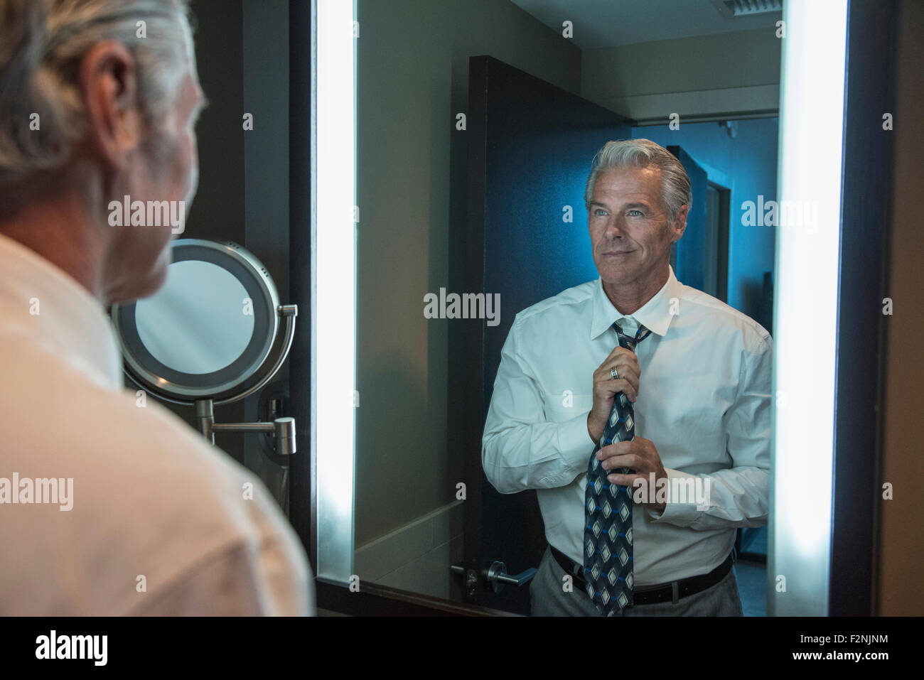Men adjusting tie in mirror hi-res stock photography and images - Alamy