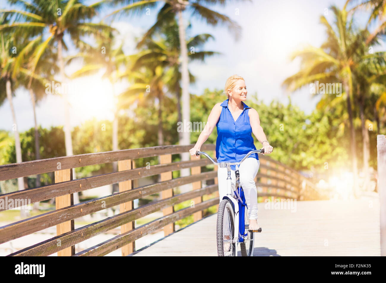Caucasian woman riding bicycle on bridge Stock Photo - Alamy