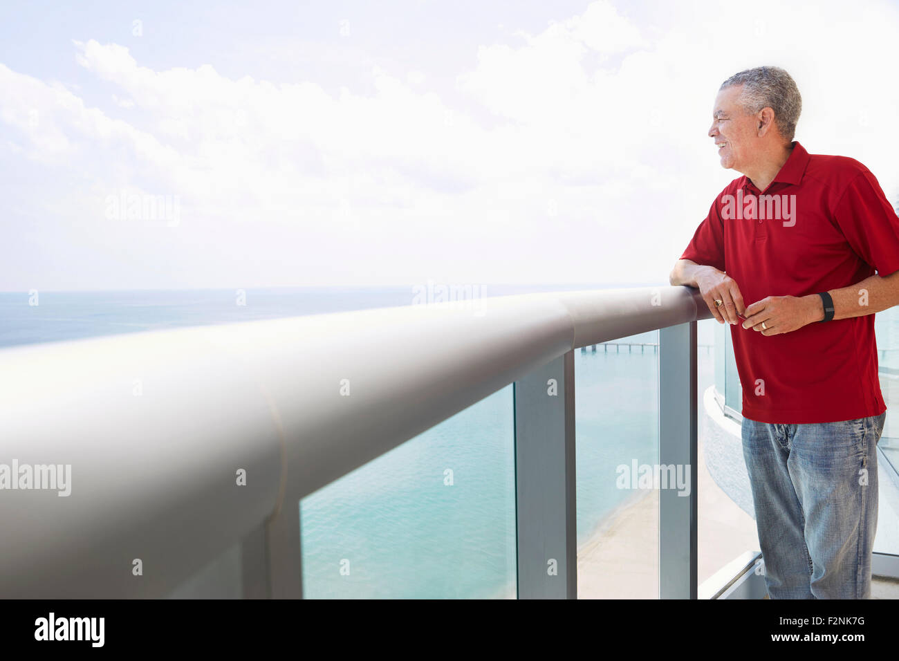 Older Black man overlooking ocean from balcony Stock Photo - Alamy