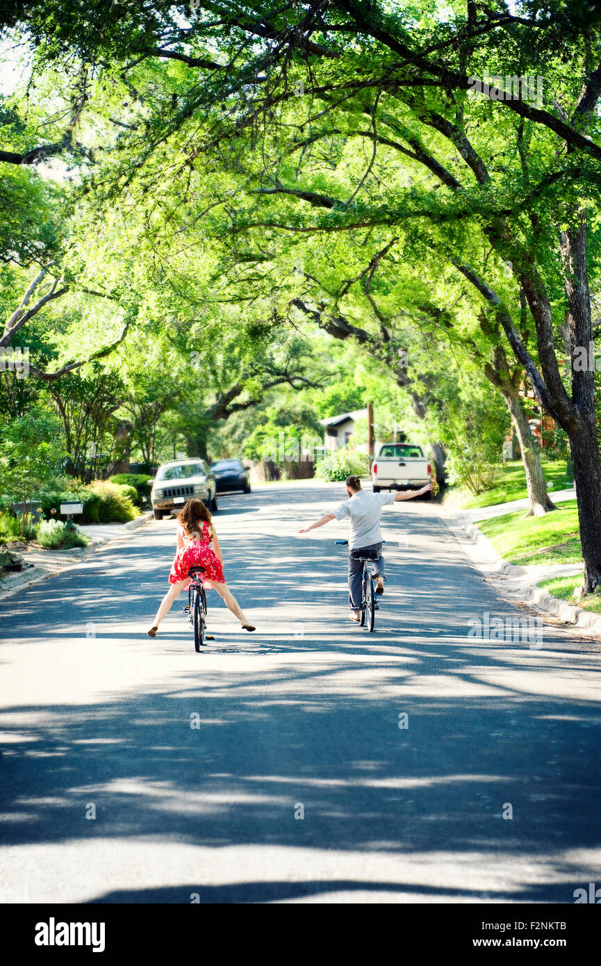 Caucasian children riding bicycles on suburban neighborhood street ...