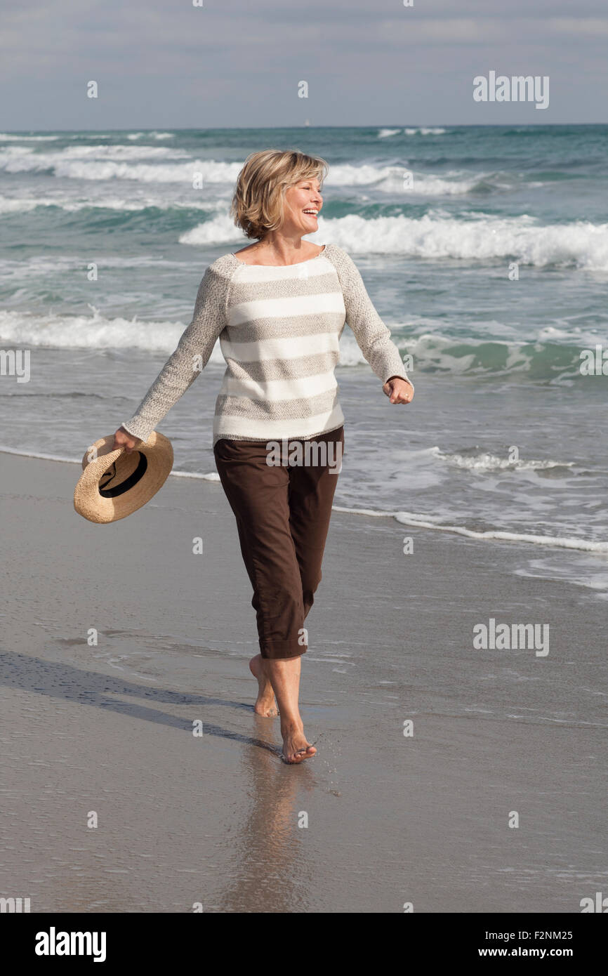 Caucasian woman walking on beach Stock Photo - Alamy