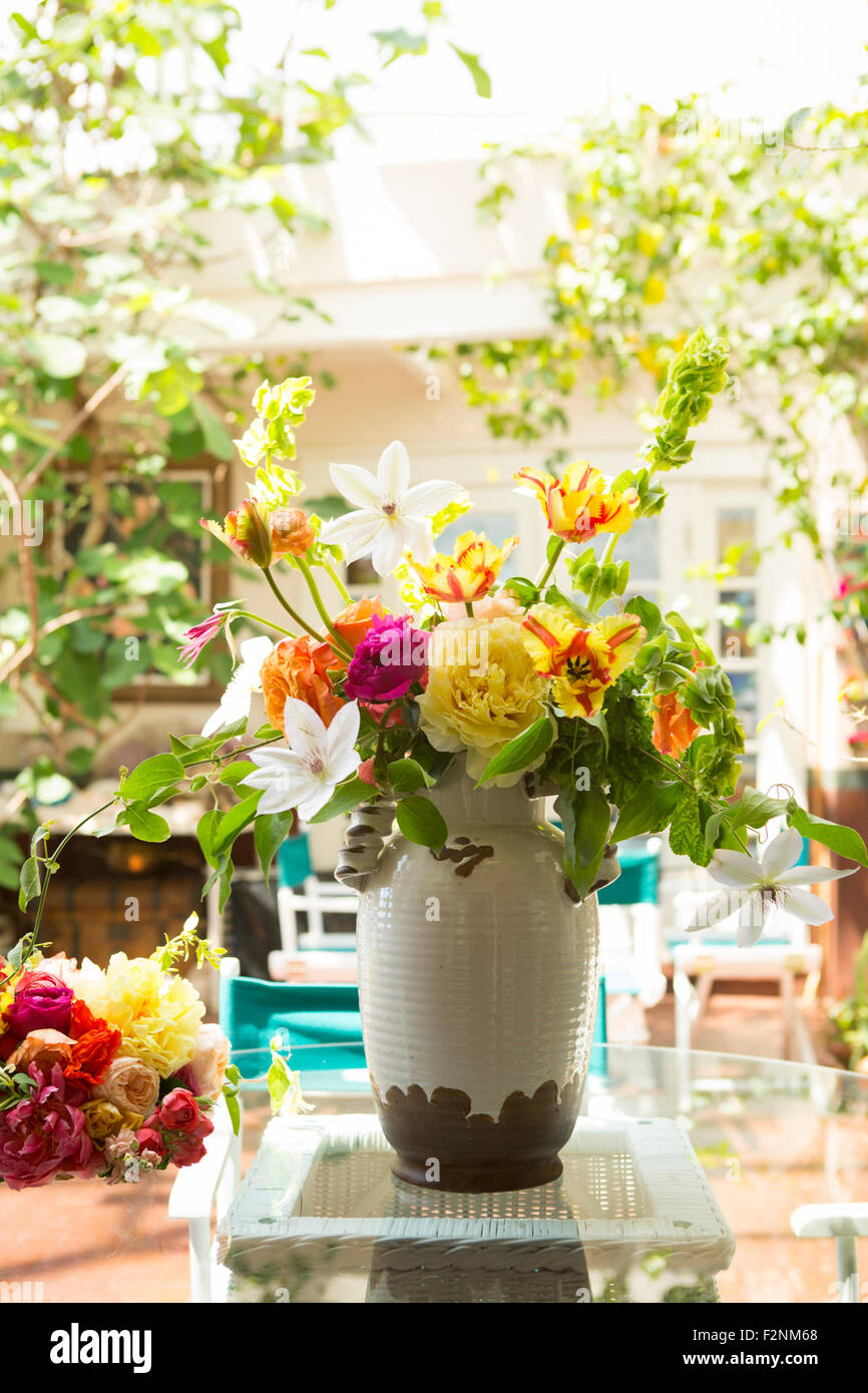 Bouquet of flowers in vase on backyard patio Stock Photo - Alamy