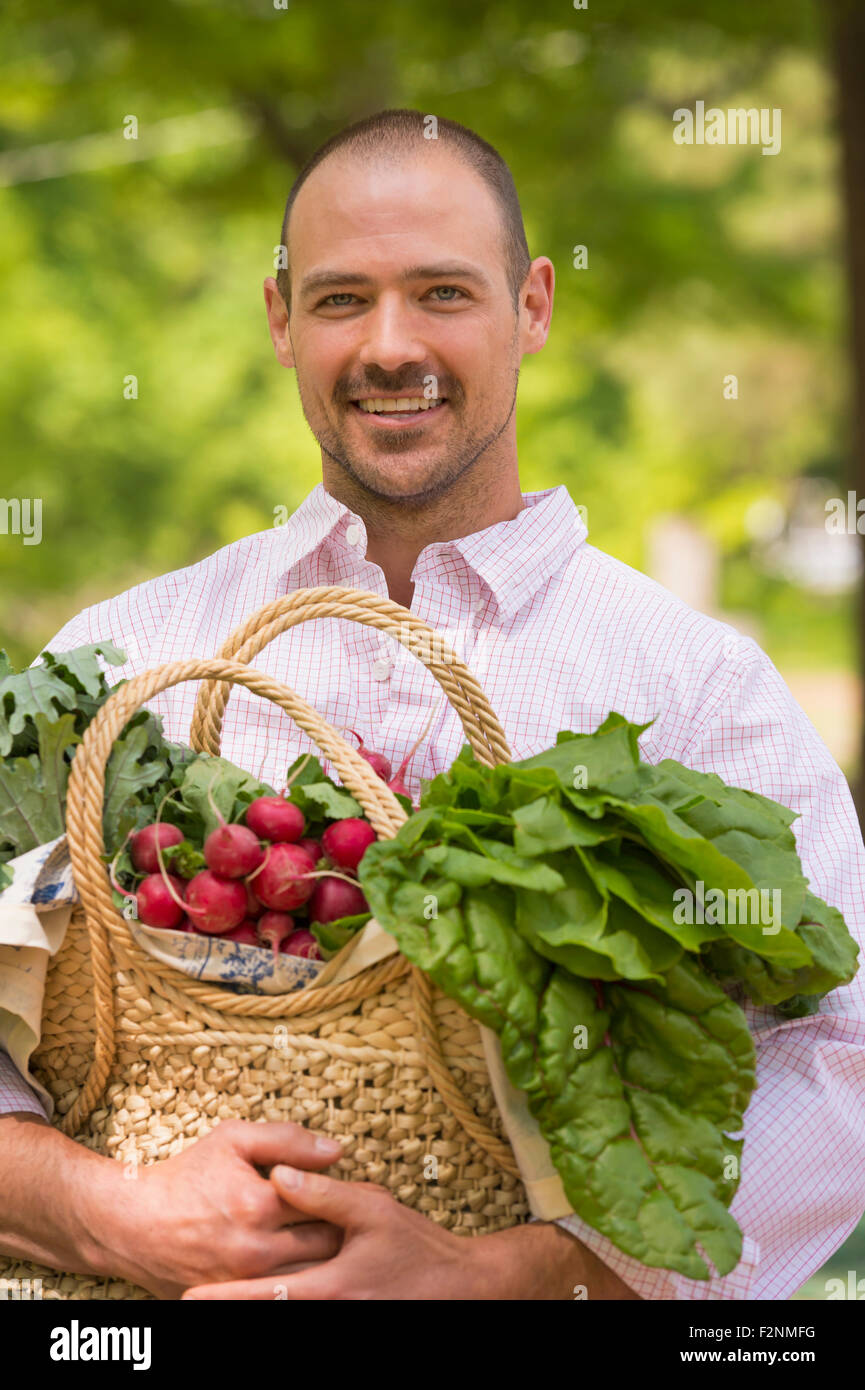 Caucasian man carrying basket of fresh produce Stock Photo - Alamy