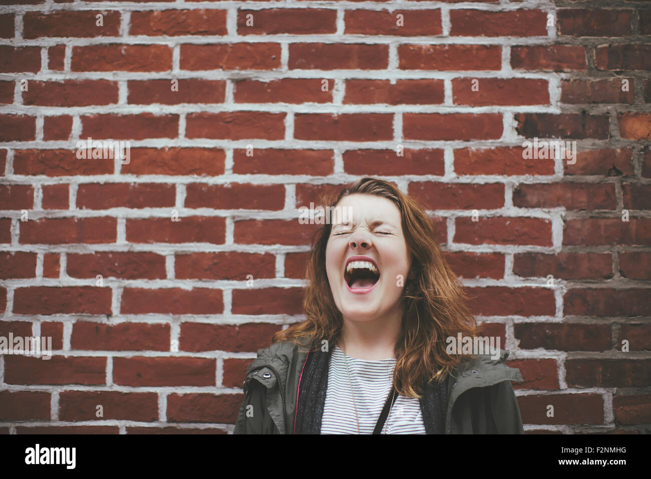 Caucasian woman shouting at brick wall Stock Photo - Alamy