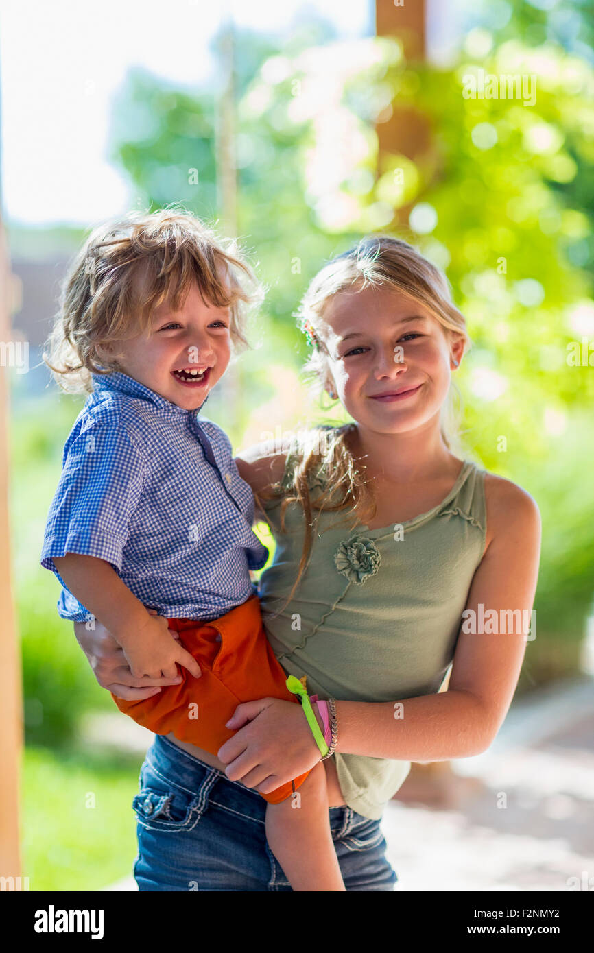 Caucasian girl holding baby brother Stock Photo - Alamy